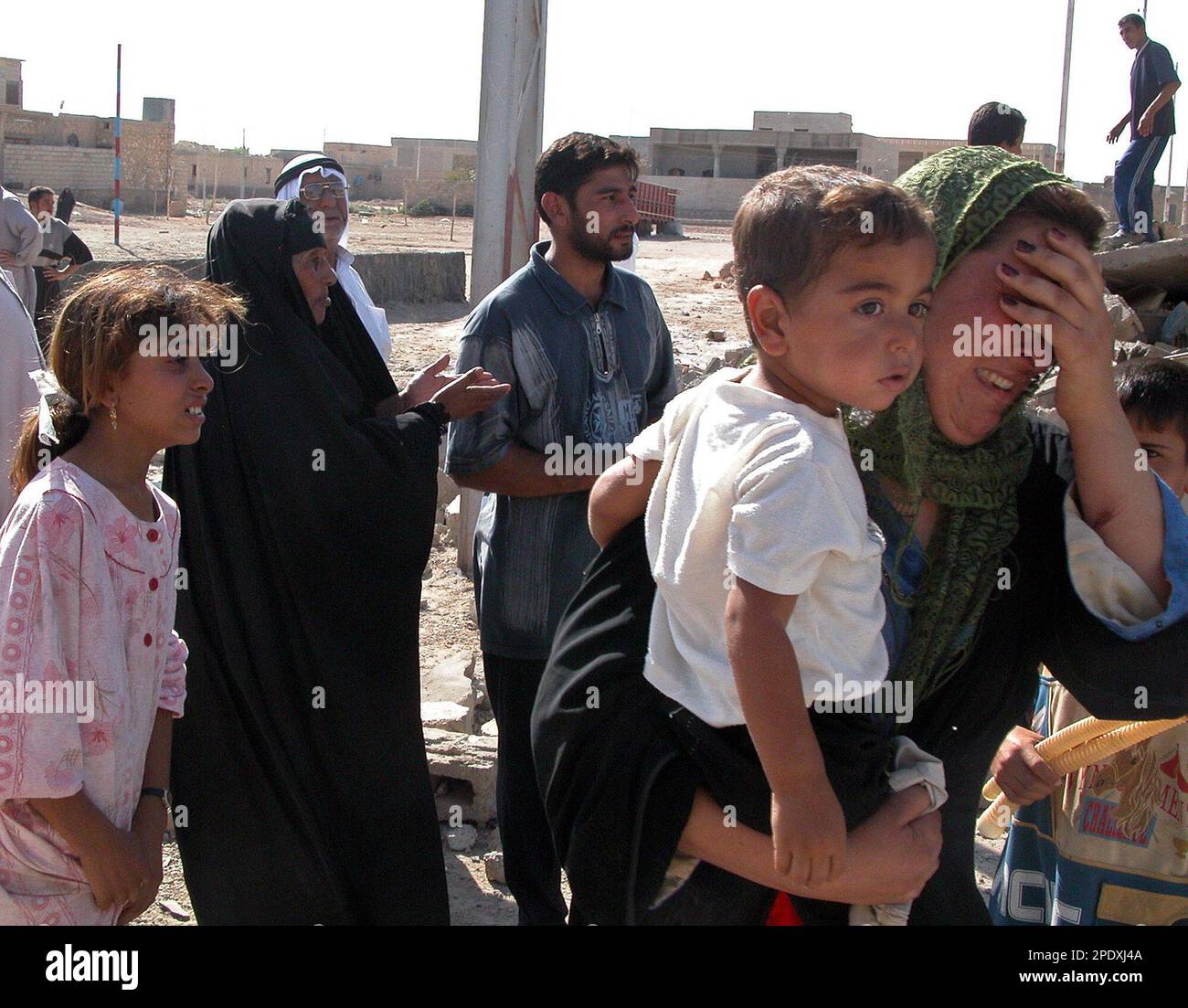 Residents and neighbours gather around a house damaged in a rocket ...
