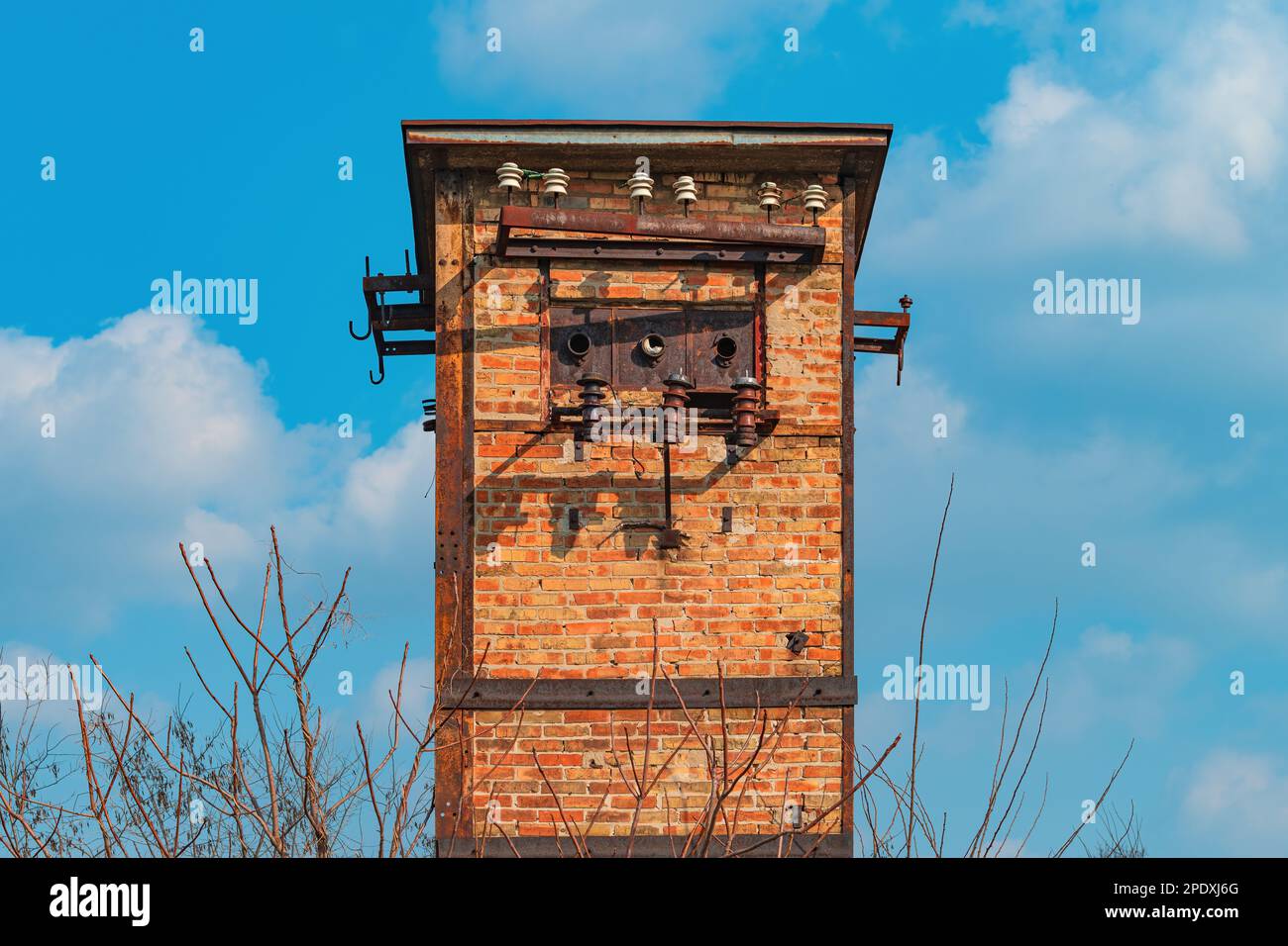 Old worn abandoned electricity cabin tower made of bricks, against blue ...