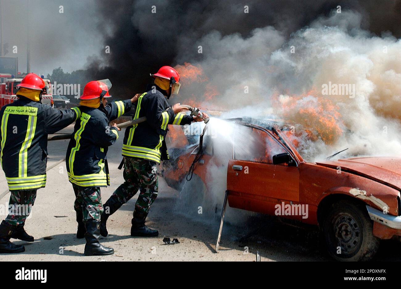Lebanese firefighters extinguish the fire in a car during a bomb ...