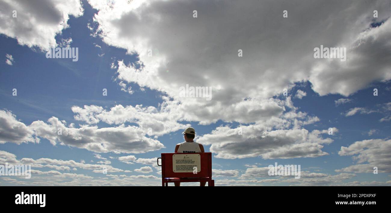 Clouds float by as a lifeguard keeps watch at a beach on the Ottawa ...
