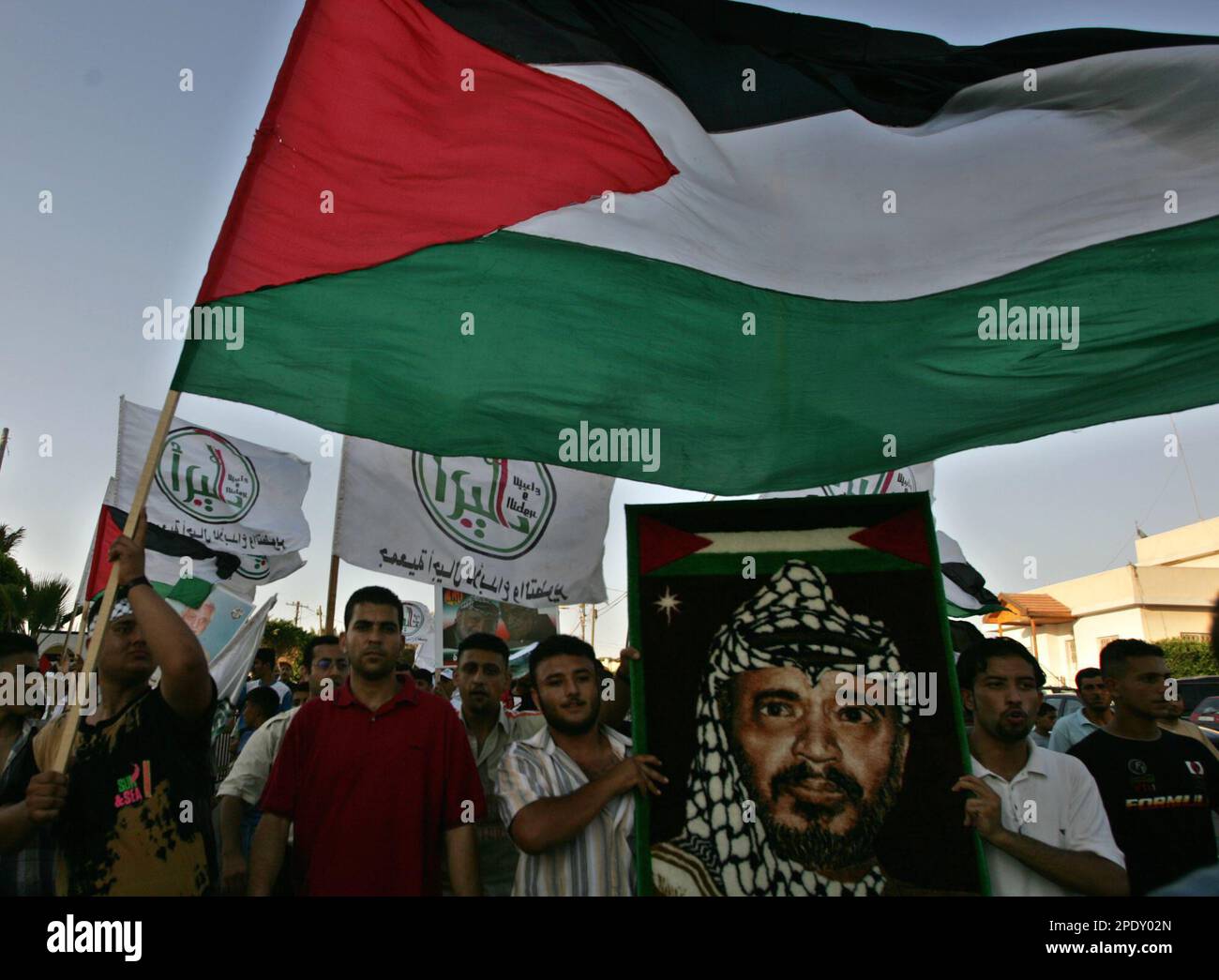 Palestinians wave their flag and hold a portrait of late leader Yasser ...