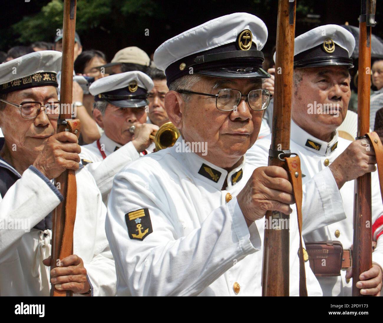 A group of Japanese Imperial Navy veterans stand at attention as they ...