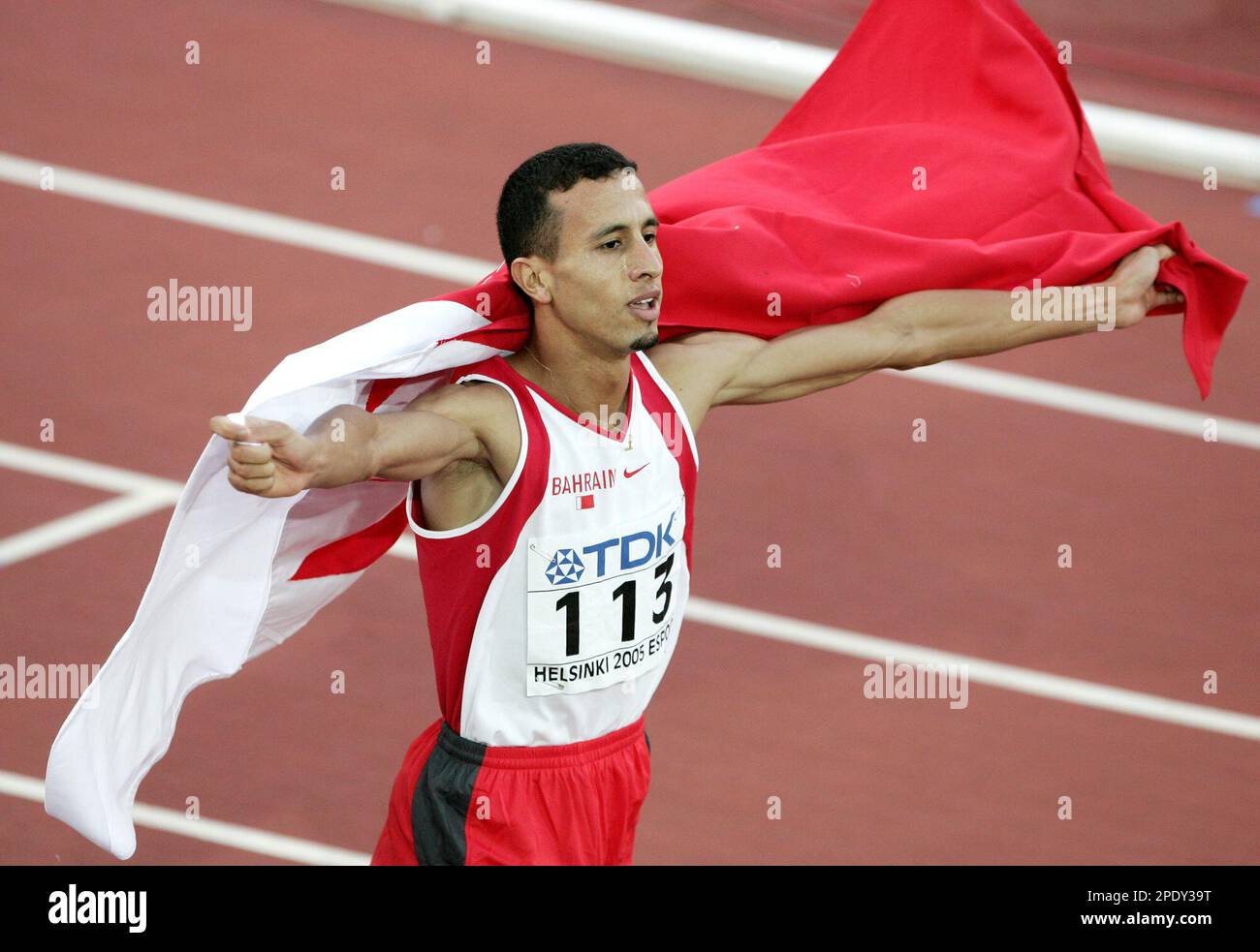 Bahrain's Rashid Ramzi carries his country's flag, after winning the ...