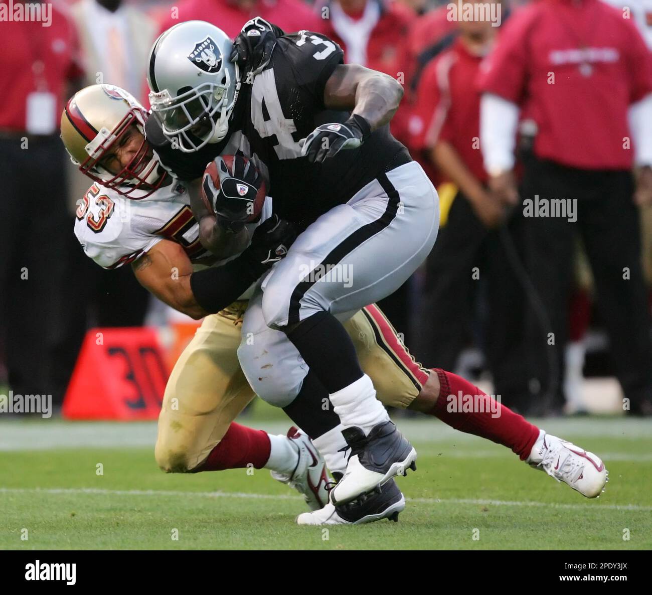 Oakland Raiders running back Lamont Jordan, right, is brought down by ...