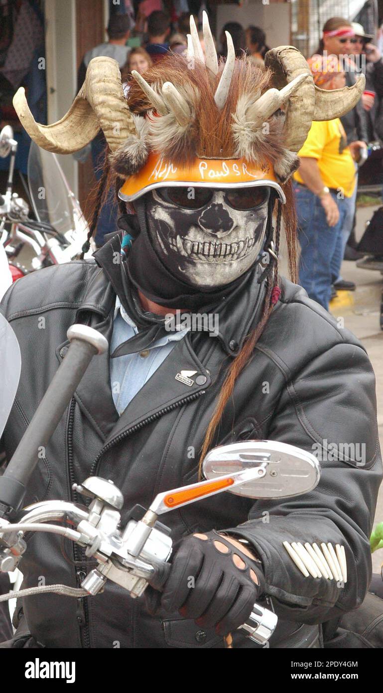 A biker rides on Main Street while wearing a full face mask and a ...