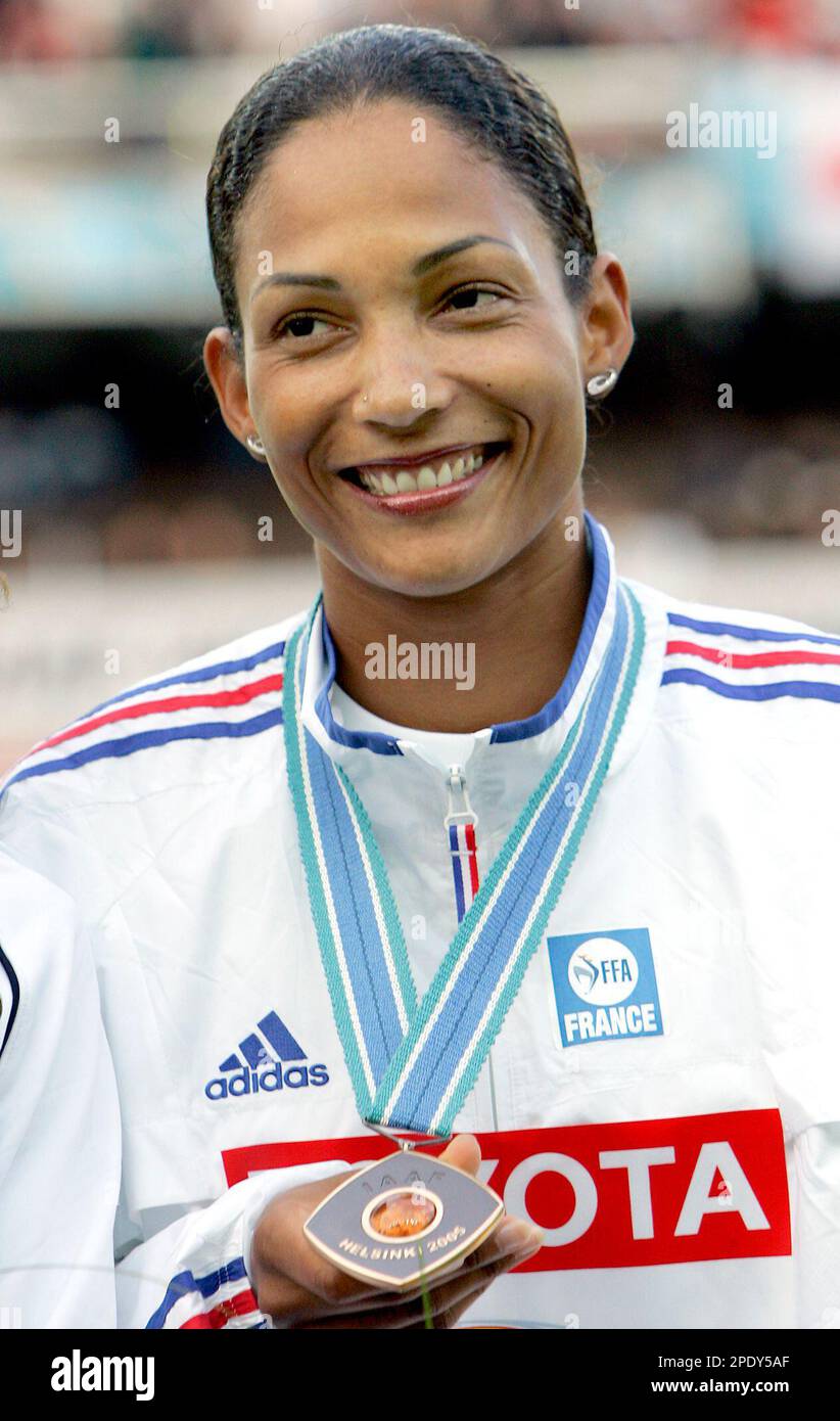 Christine Arron of France smiles as she shows the bronze medal she won ...