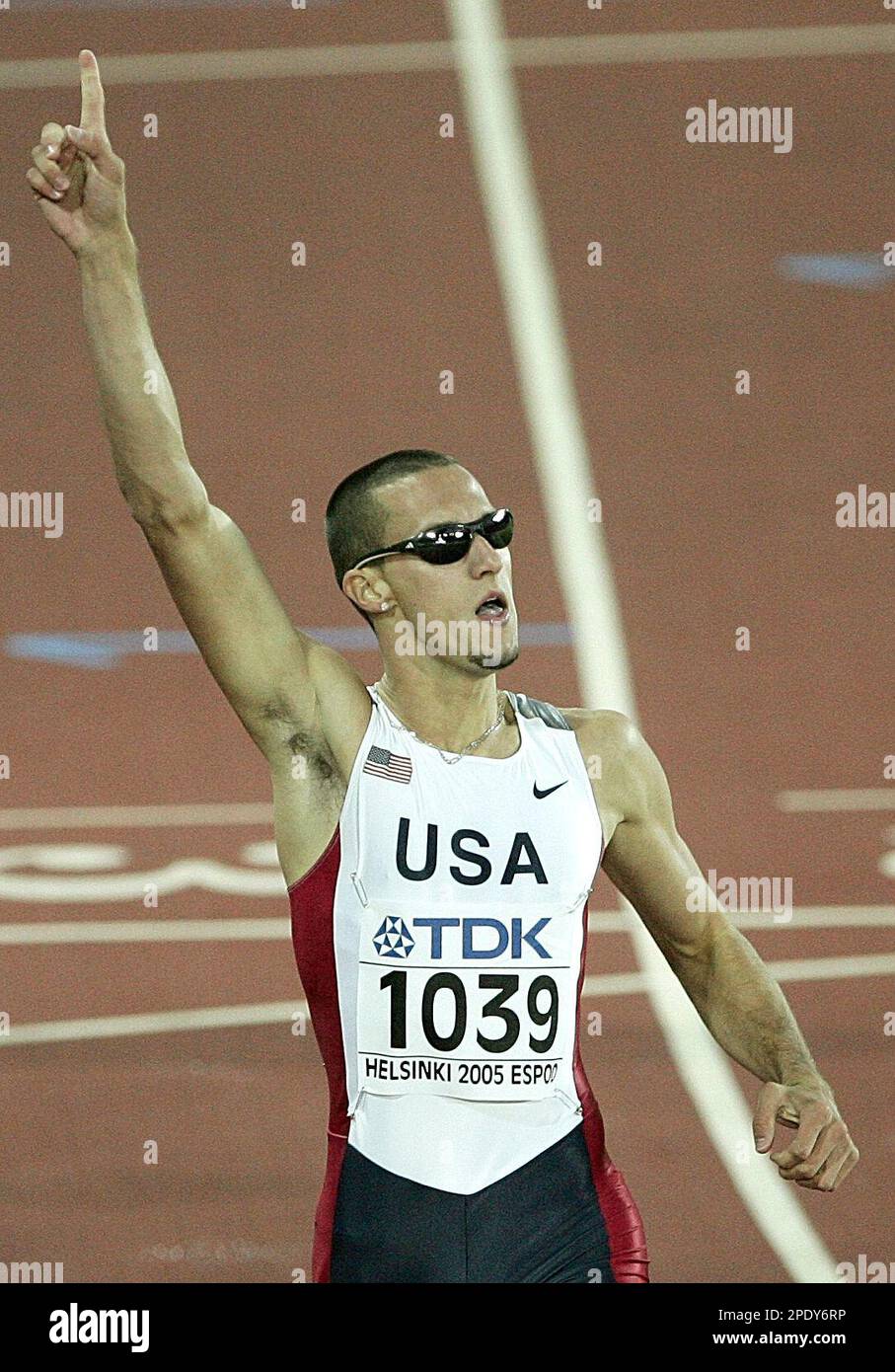 Jeremy Wariner of the US raises his hand after crossing the line to win ...