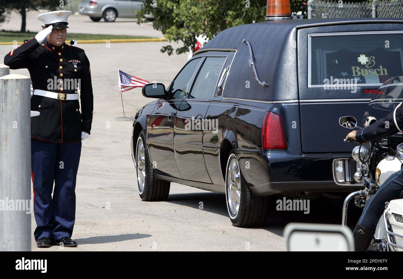 A Marine salutes as the hearse carrying the casket of Cpl. Jeff ...