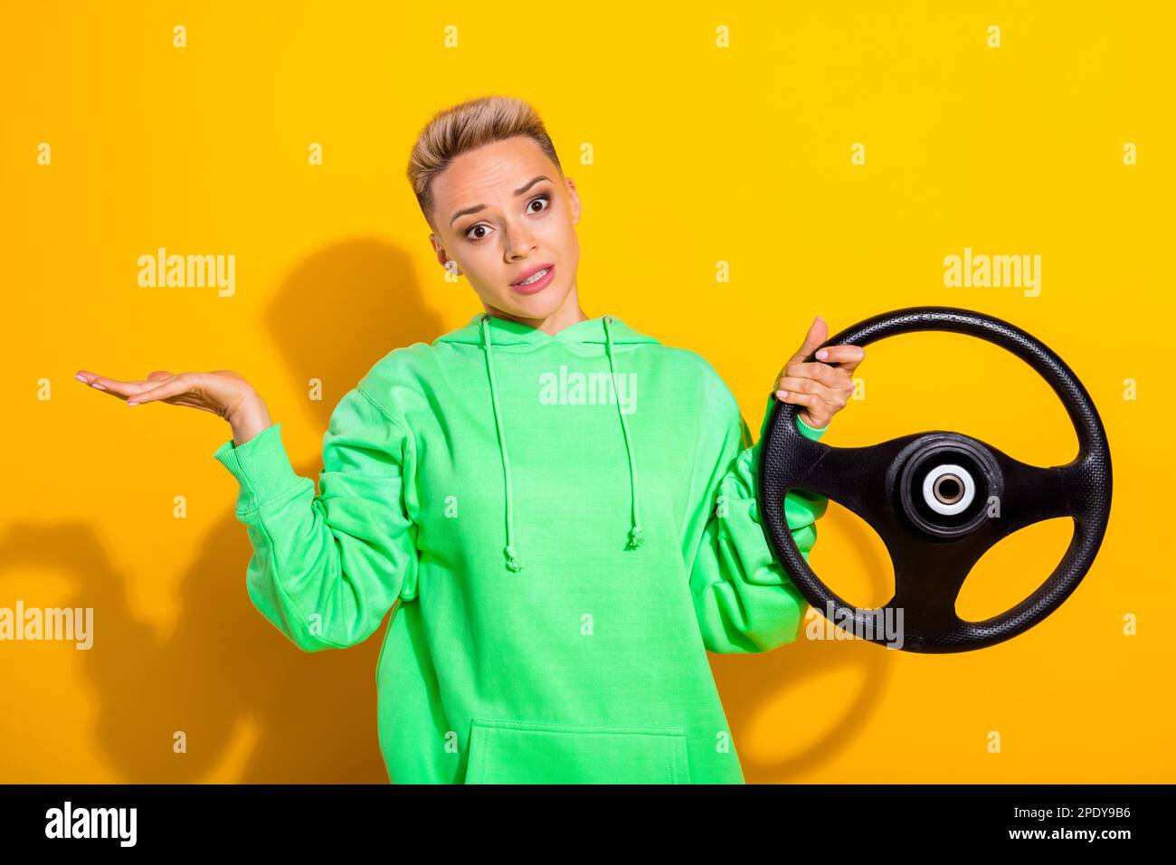 Portrait of clueless girl hand hold wheel shrug shoulders isolated on ...