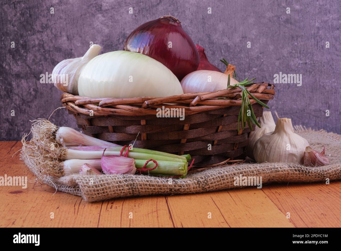Country still life of vegetables, onions, spring garlic, garlic cloves ...