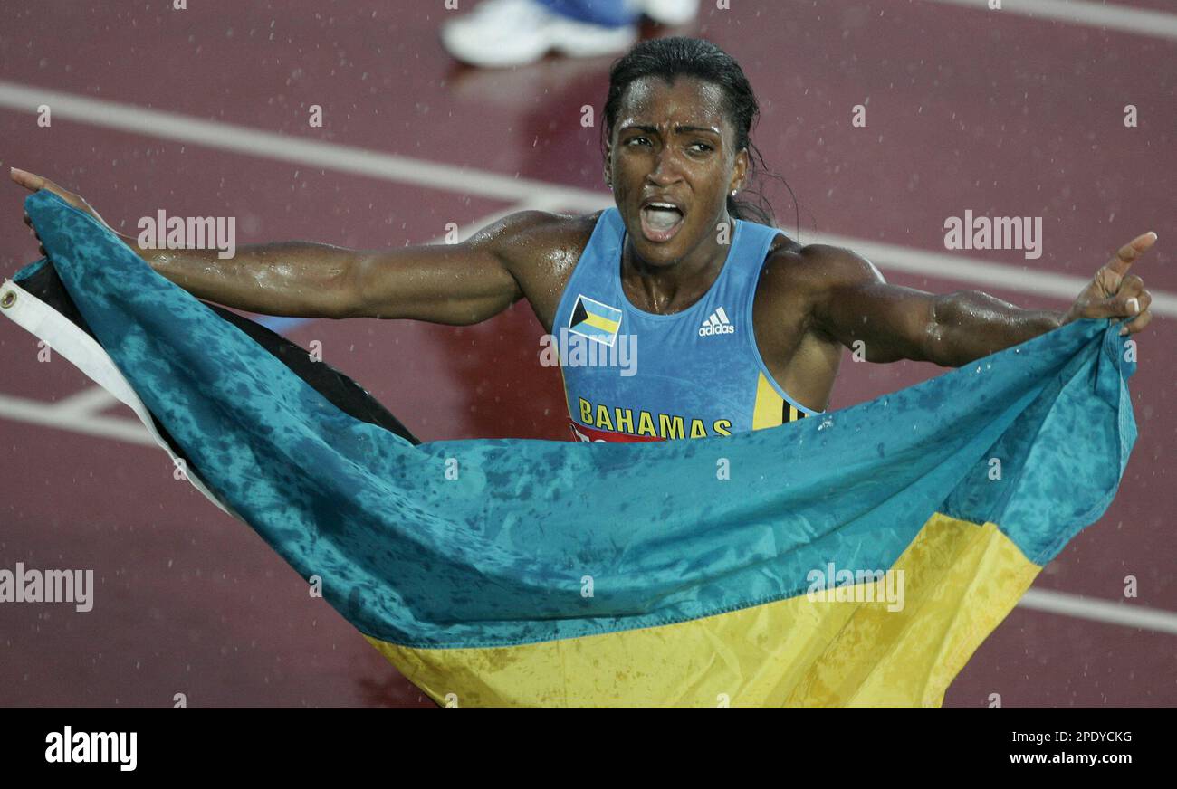 Tonique Williams-Darling of the Bahamas holds her nation's flag in the ...