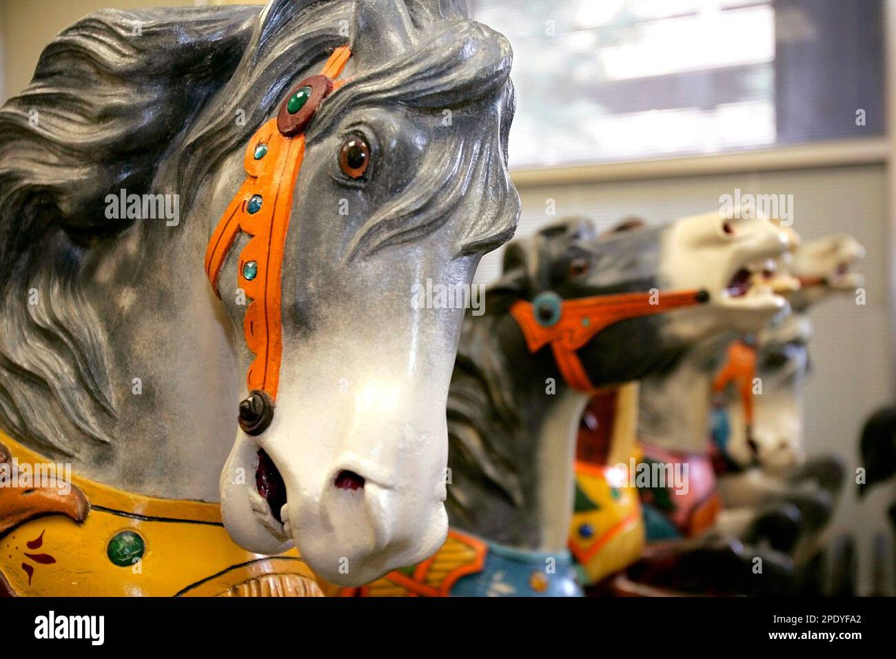 Some of the 40 restored carousel ponies sit in a row at a downtown ...