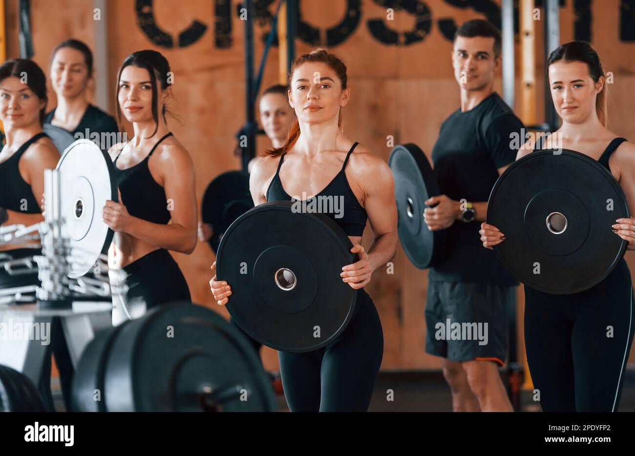 Holding weights. Group of young sportive people have crossfit day ...