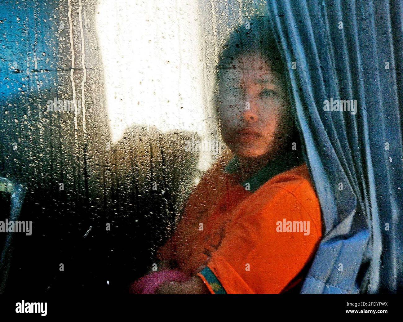 Rain streaks down the window of a Bangkok, Thailand, city bus Tuesday ...