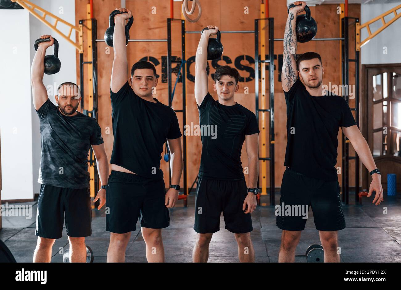 Lifting of heavy weights. Group of young sportive people have crossfit ...