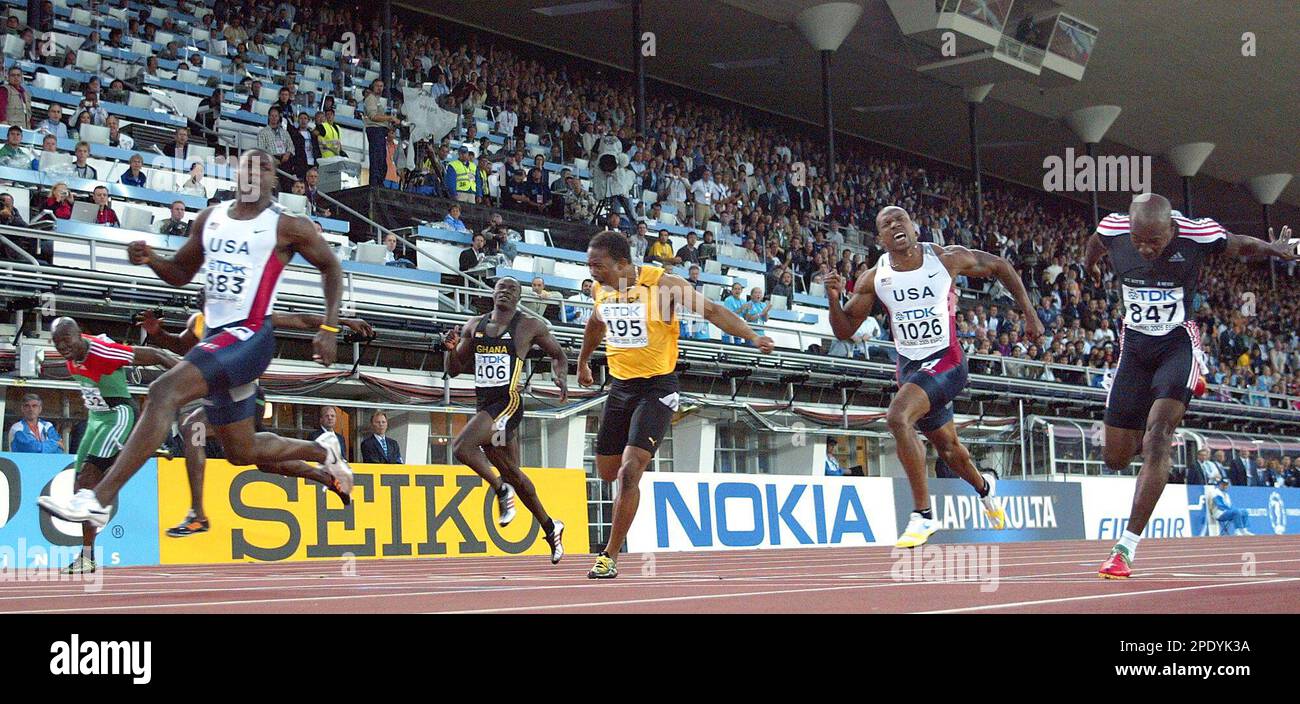 Justin Gatlin of the US, left, crosses the finish line to win the gold ...