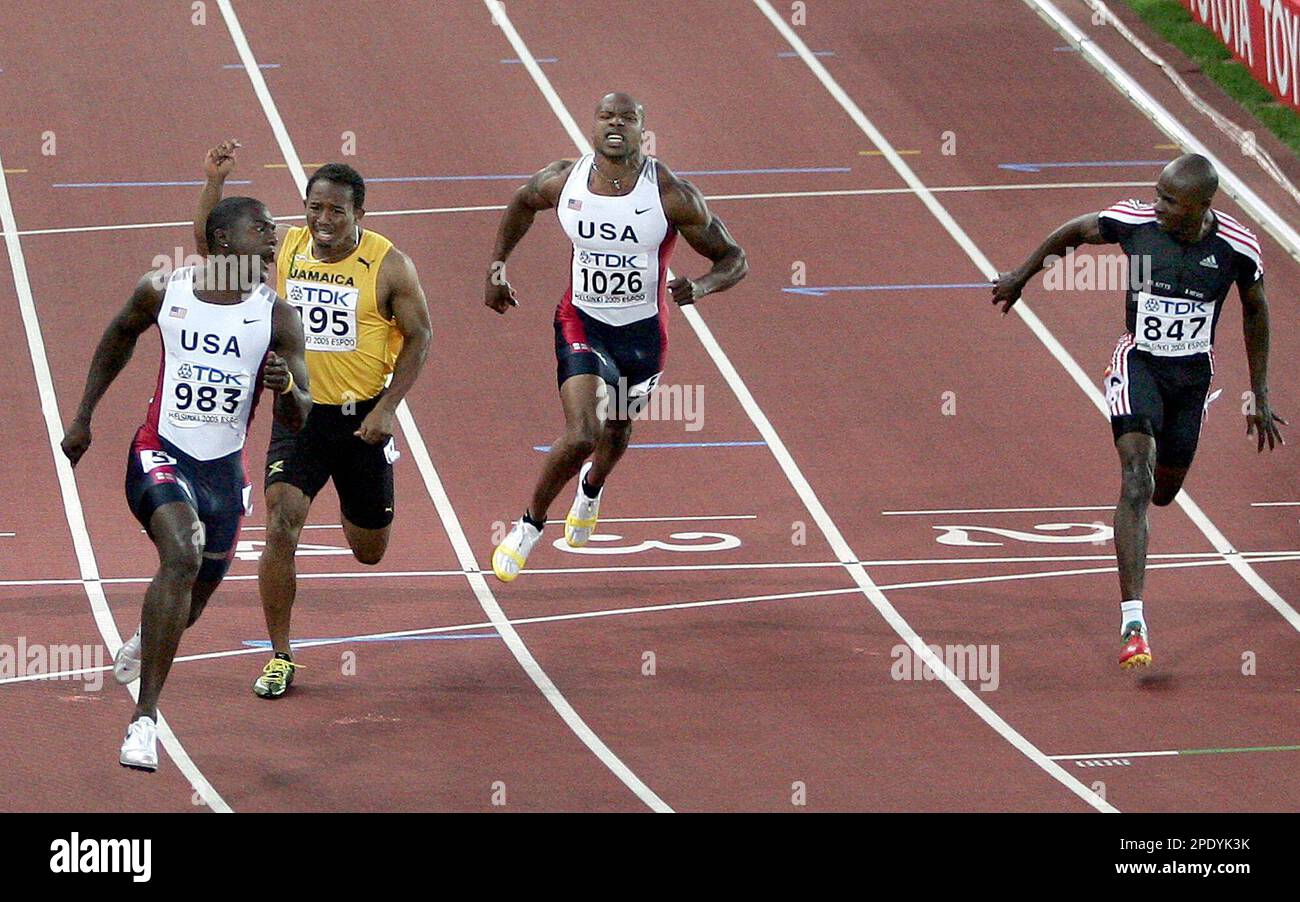 Justin Gatlin of the US, left, crosses the finish line to win the gold ...