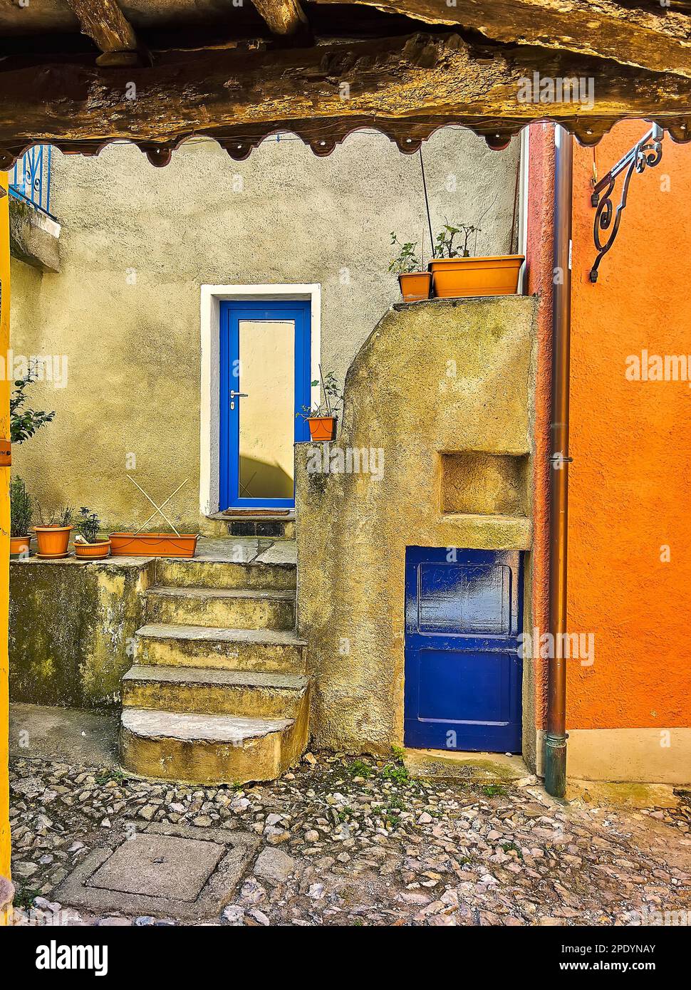 The tiny yard in a maze of medieval town streets with bright blue doors ...