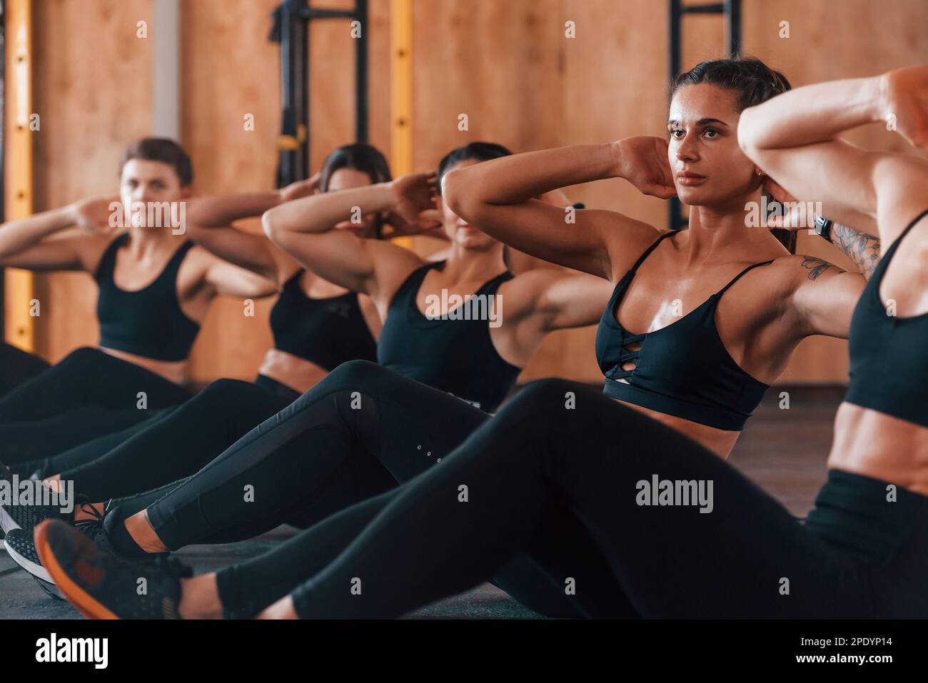 Busy by doing exercises. Group of young sportive people have crossfit ...