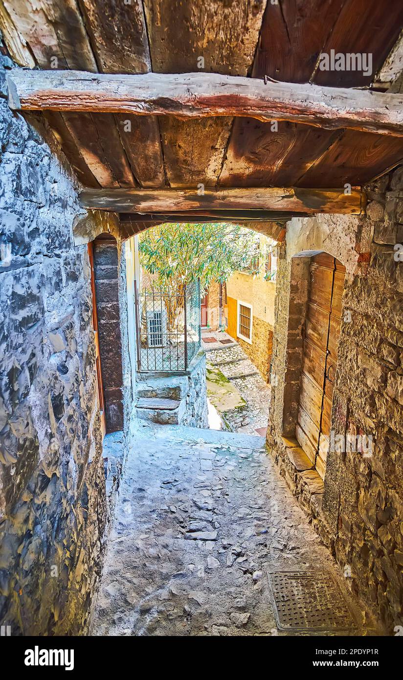The narrow covered passage with stone walls and timber ceiling ...