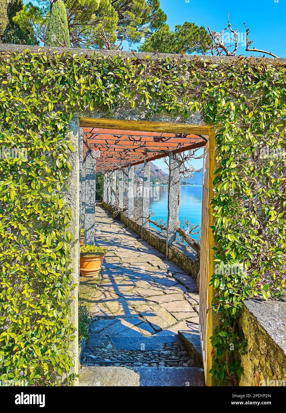 The scenic lakeside garden with a vintage pergola passageway, located ...