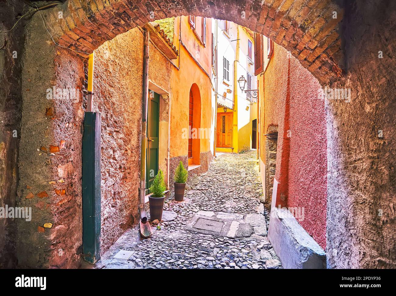 The arched pass opens the view on the narrow medieval stone street ...