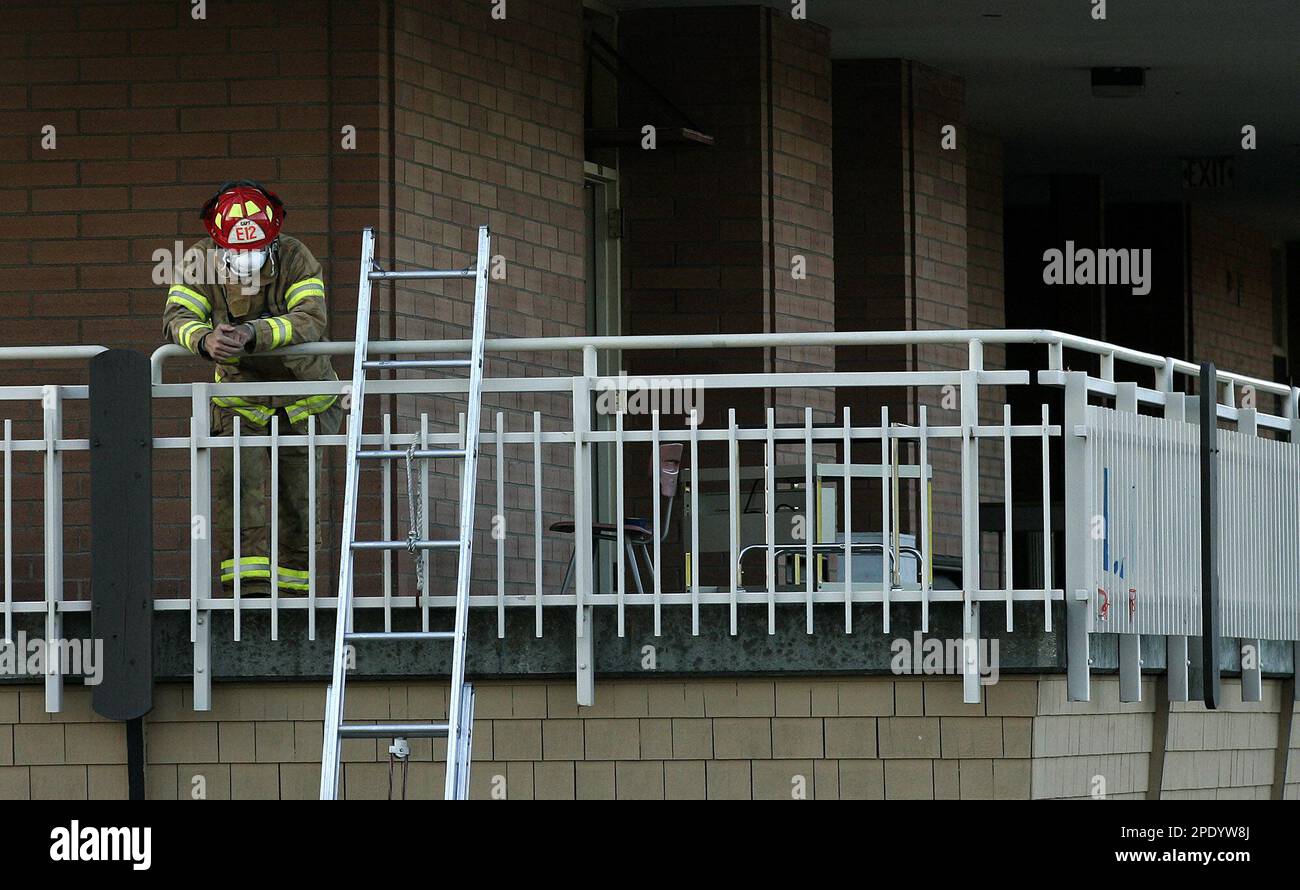 Wearing a surgical mask, a captain with the Renton Fire Dept. rests ...