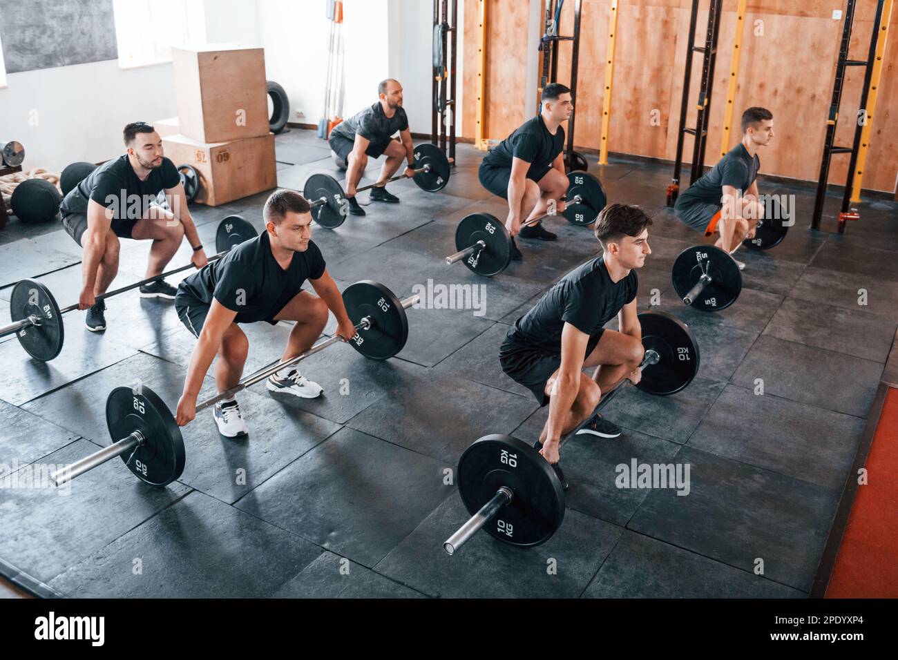 Busy by doing exercises. Group of young sportive people have crossfit ...