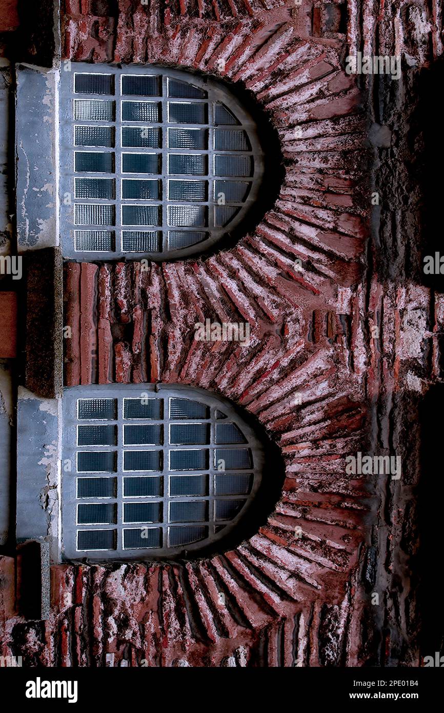 A classic red brick building featuring two barred windows with an ...