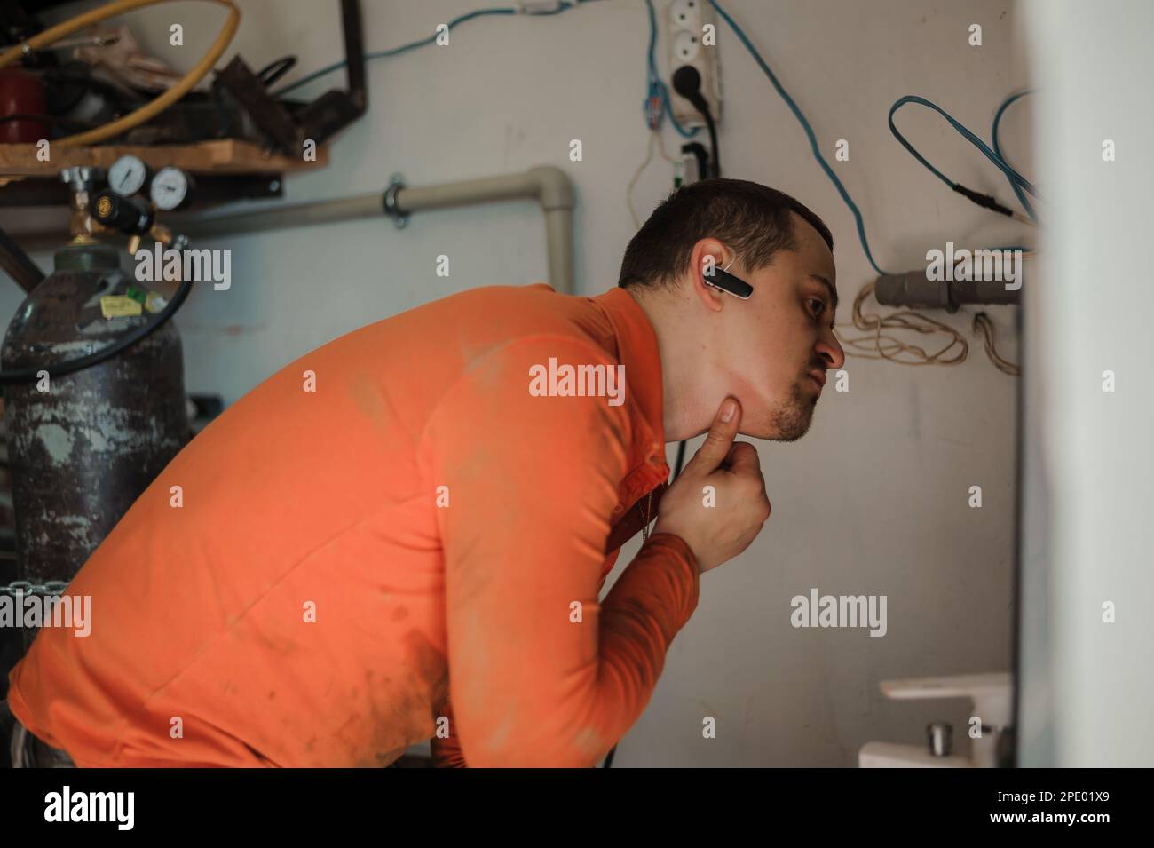 Male auto mechanic washing his hands after car repair. Worker washes ...