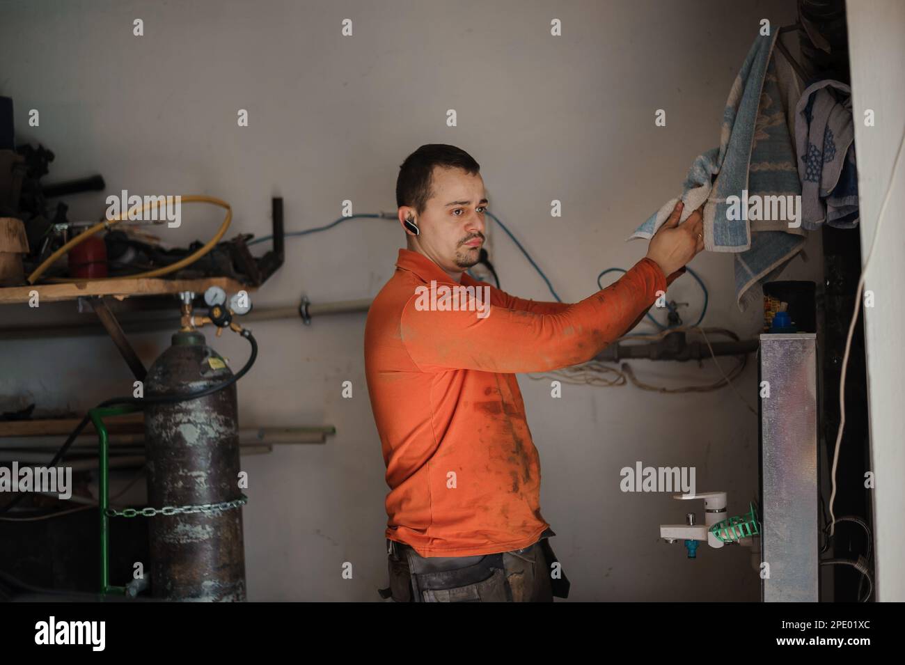 Male auto mechanic washing his hands after car repair. Worker washes ...