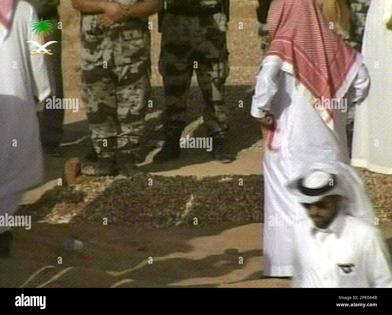 This image made from Saudi TV shows mourners standing over the unmarked ...