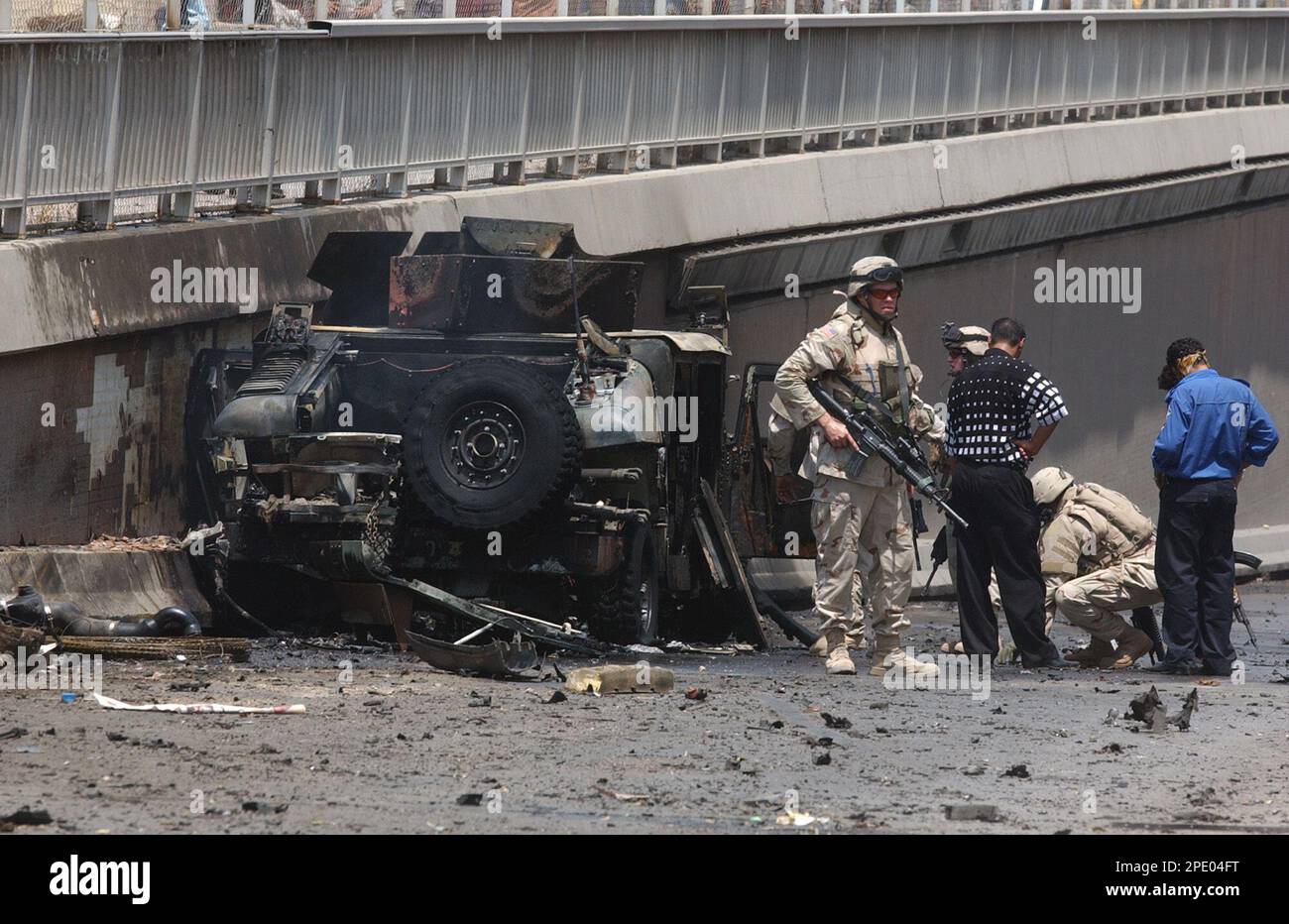A US soldier stands guard as US and Iraqi troops look for evidence ...