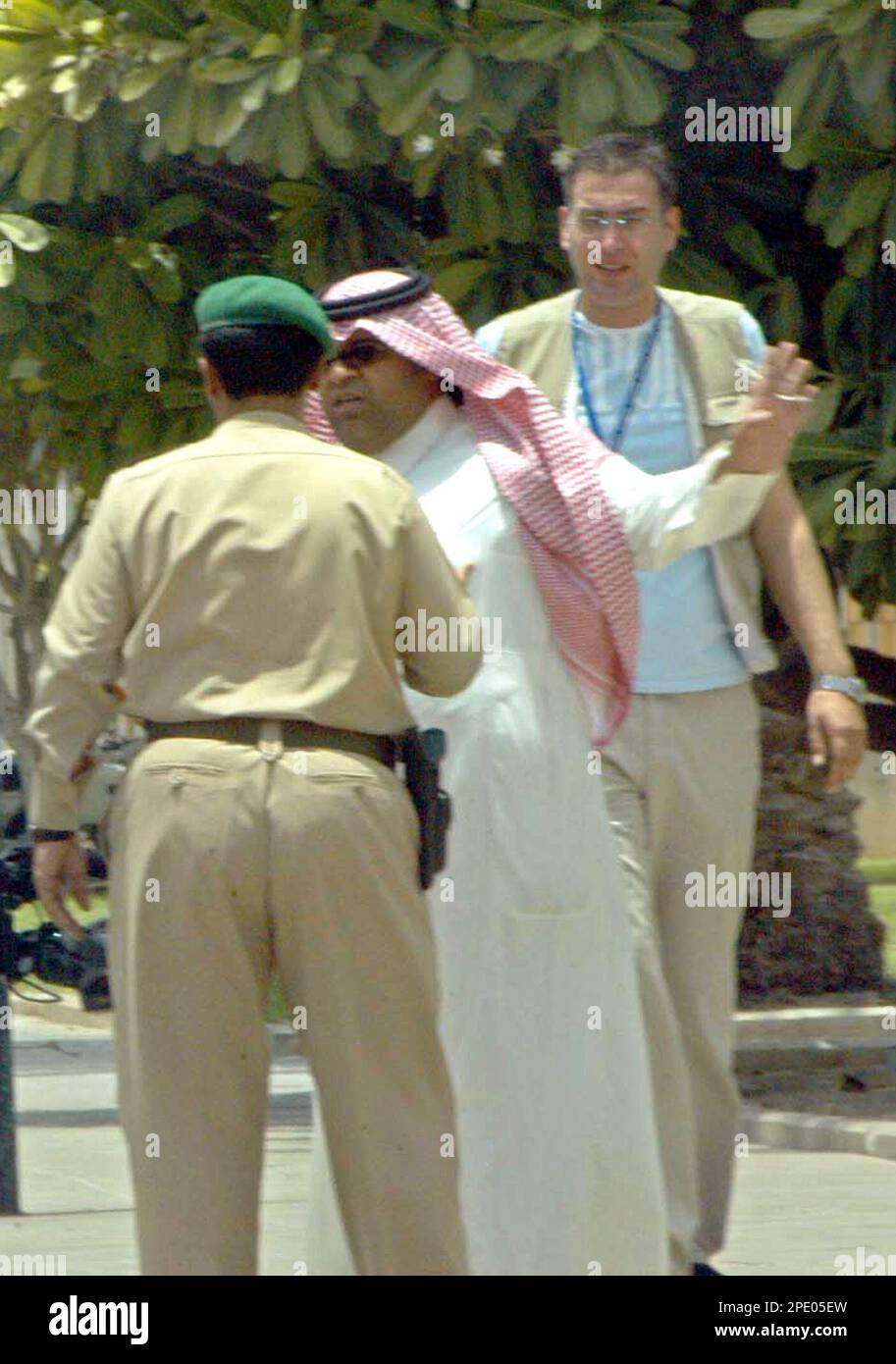 A Saudi police officer, left, checks visitors at the King Faisal ...