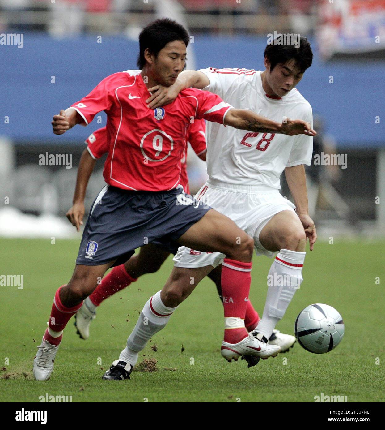 South Korea's Lee Chun-soo (9) fights for the ball against China's Li ...