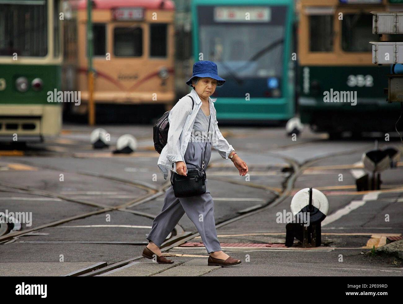 A pedestrian crosses the trolley tracks in Hiroshima, western Japan ...