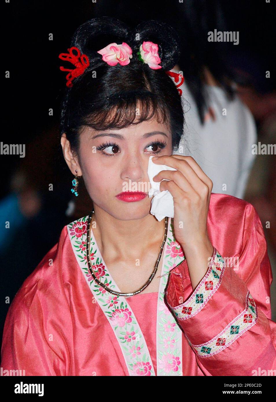 Hong Kong musical artist Perry Jiao tears as she hurts her leg during a ...