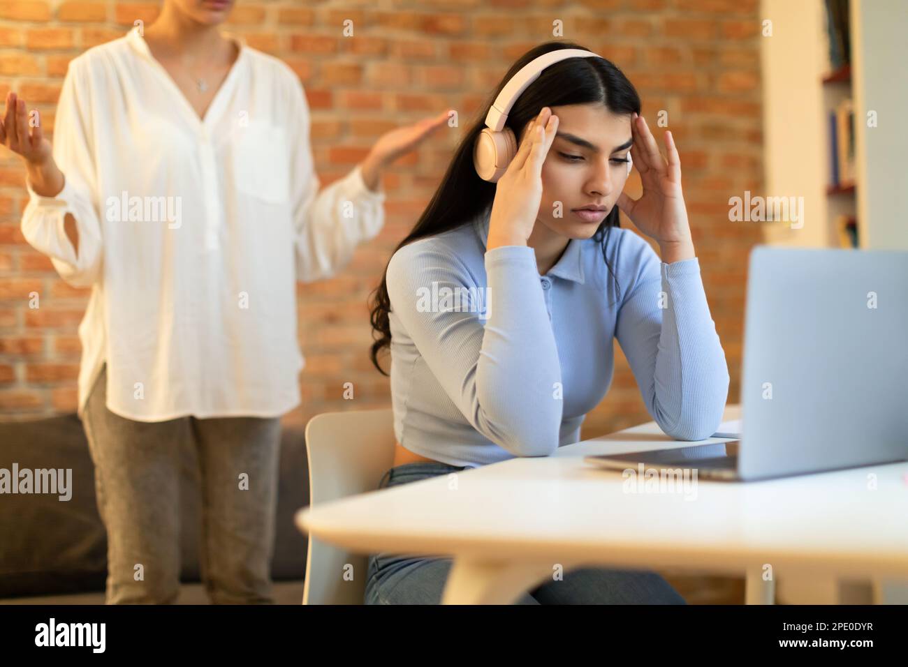 Problems between generations concept. Teen girl wearing headphones and ...