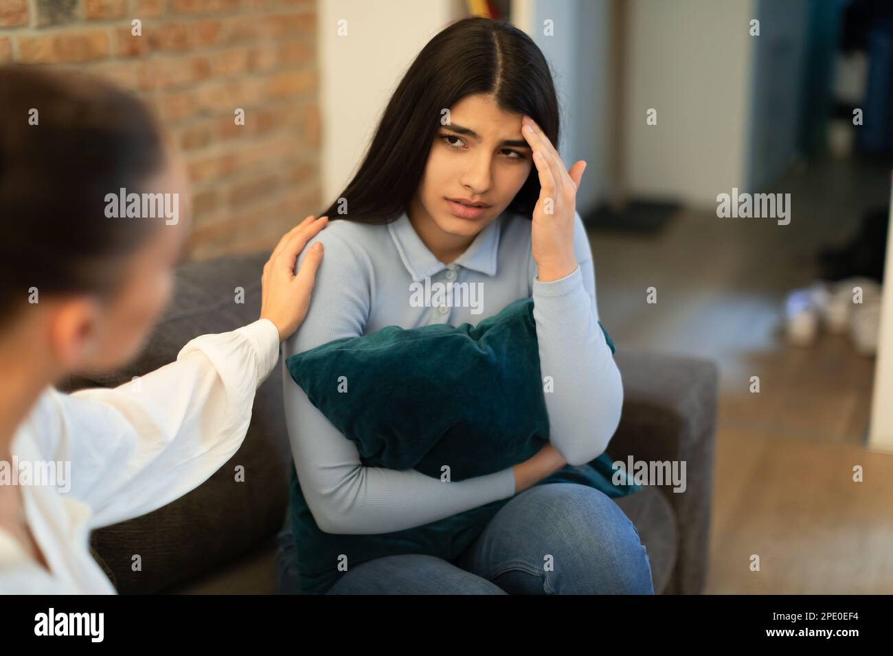 Unhappy teen lady having problem, hugging pillow and talking with ...