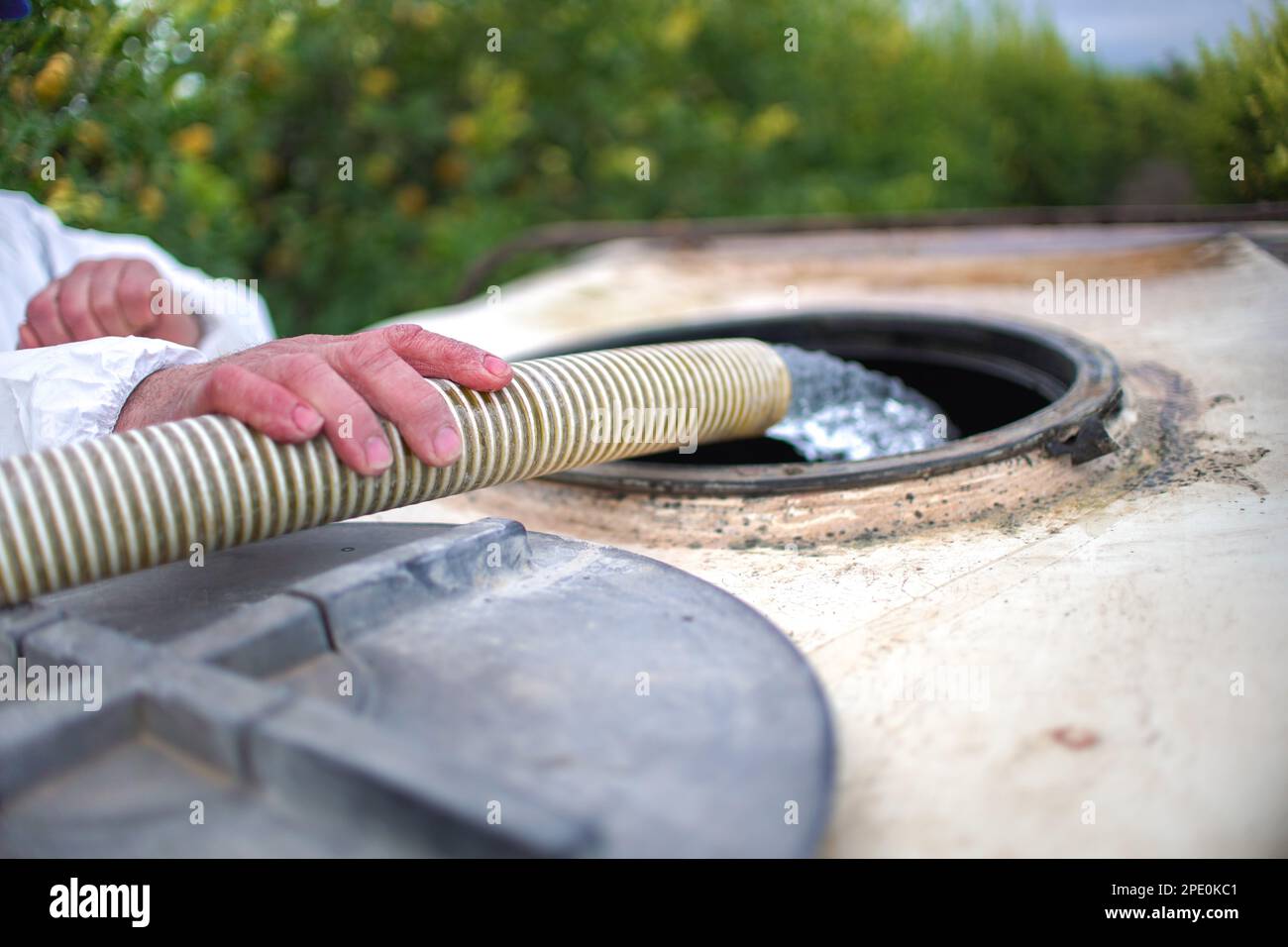 Spray ecological pesticide. Farmer fumigate in protective suit and mask ...