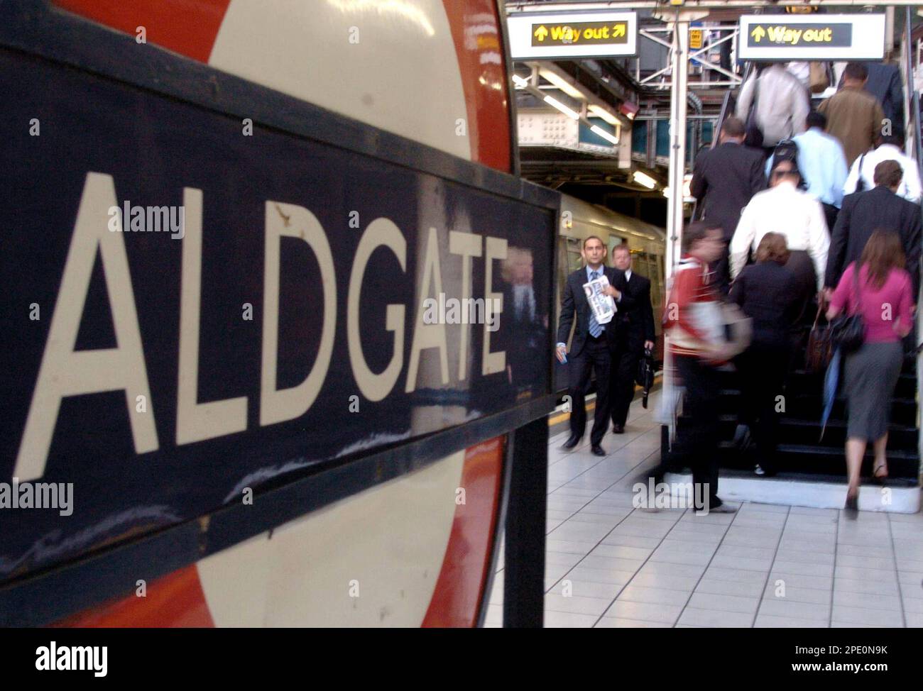Commuters get off an underground train at Aldgate Station in London ...