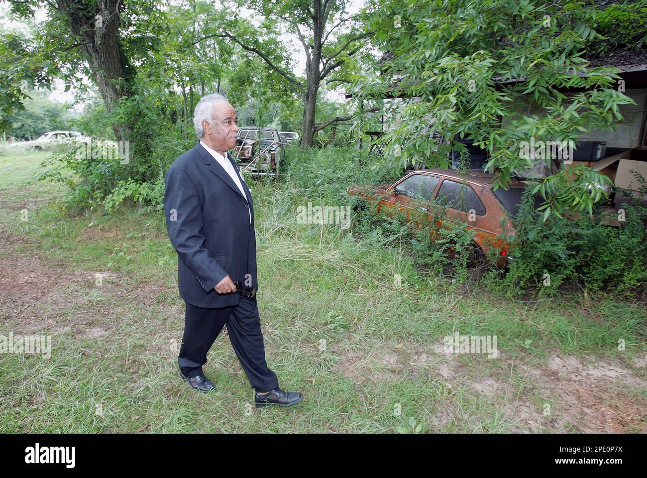 Georgia State Rep. Tyrone Brooks walks past the overgrown yard of the ...