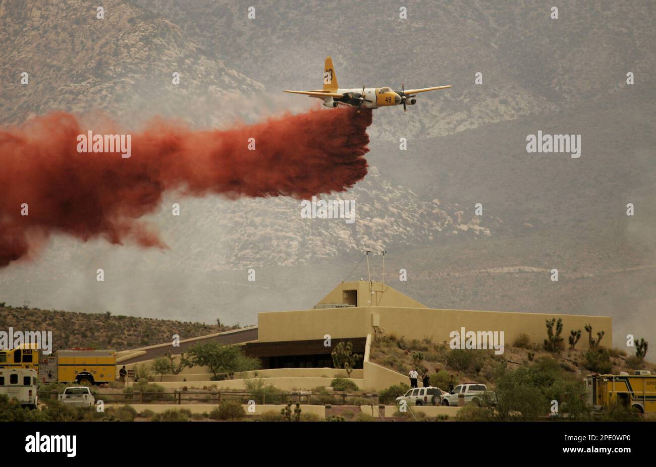 An air tanker drops slurry behind the visitor's center of the Red Rock ...