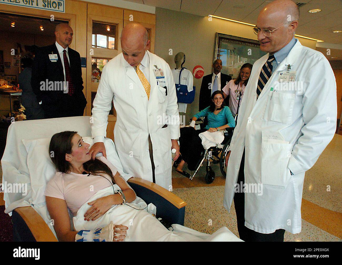 Emily Benton, left, 20, is greeted by her doctors Scott Levine and Greg ...