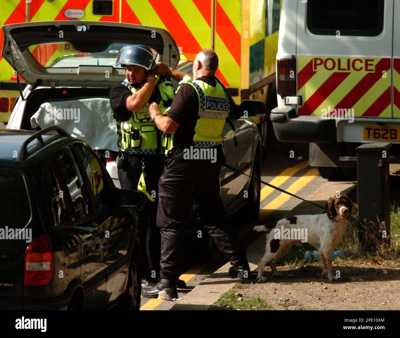 A police dog handler wearing a protective suit prepares to join the ...