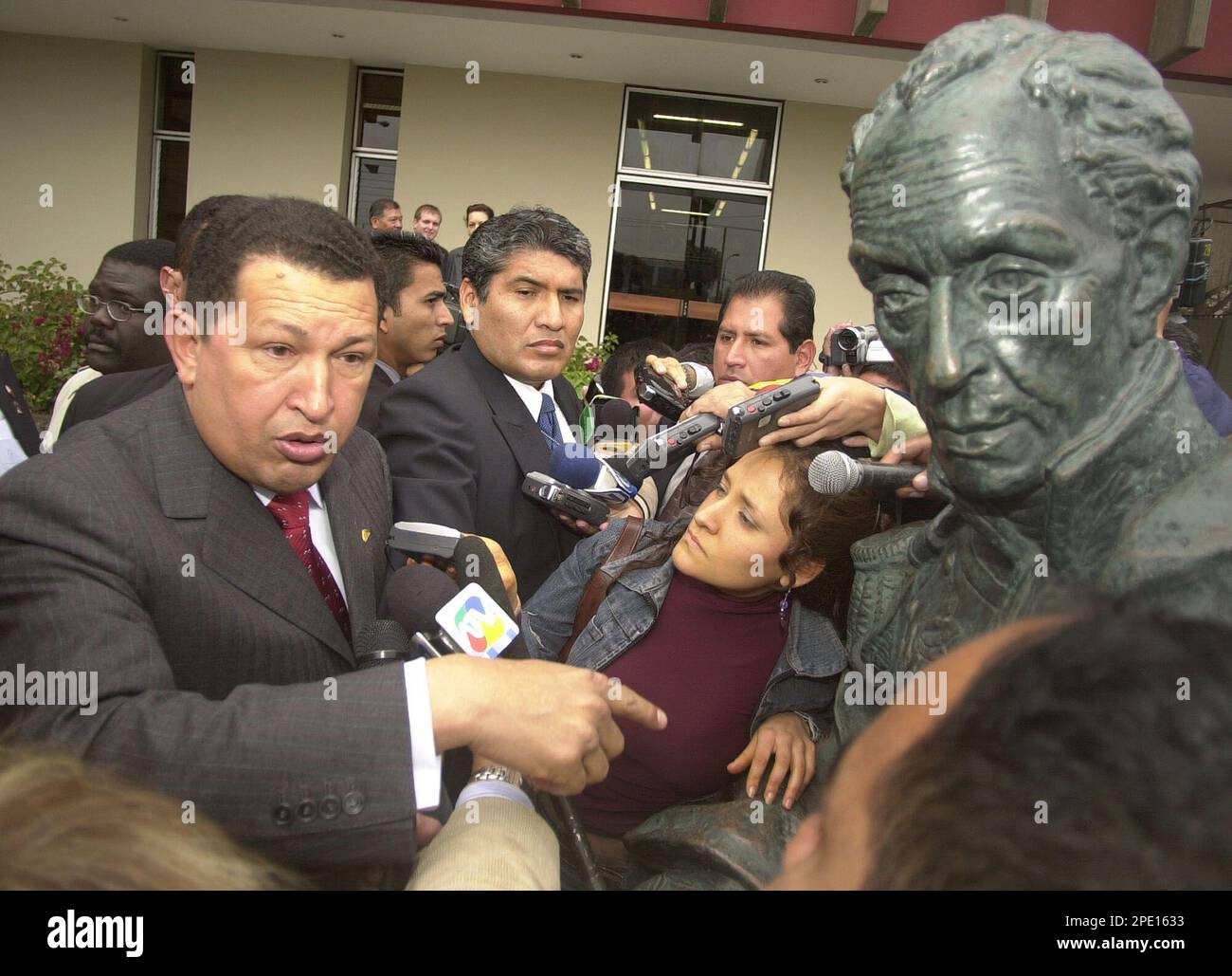 Venezuelan President Hugo Chavez, left, talks to reporters next to a ...