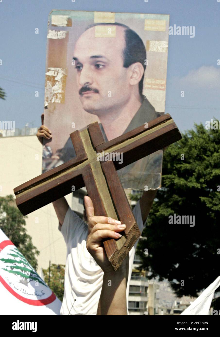 Lebanese Forces supporters hold a Lebanese Forces cross and a poster of ...