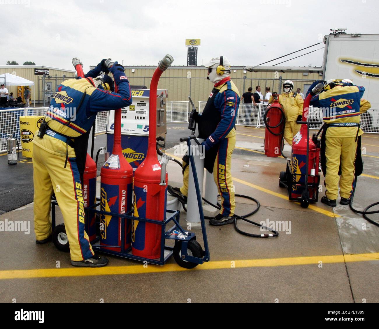 Petroleum transfer engineers load race car team gas cans with Sunoco ...