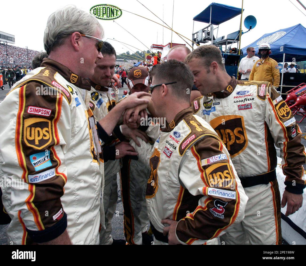 Members of the UPS Ford pit crew fire themselves up at the start of the ...