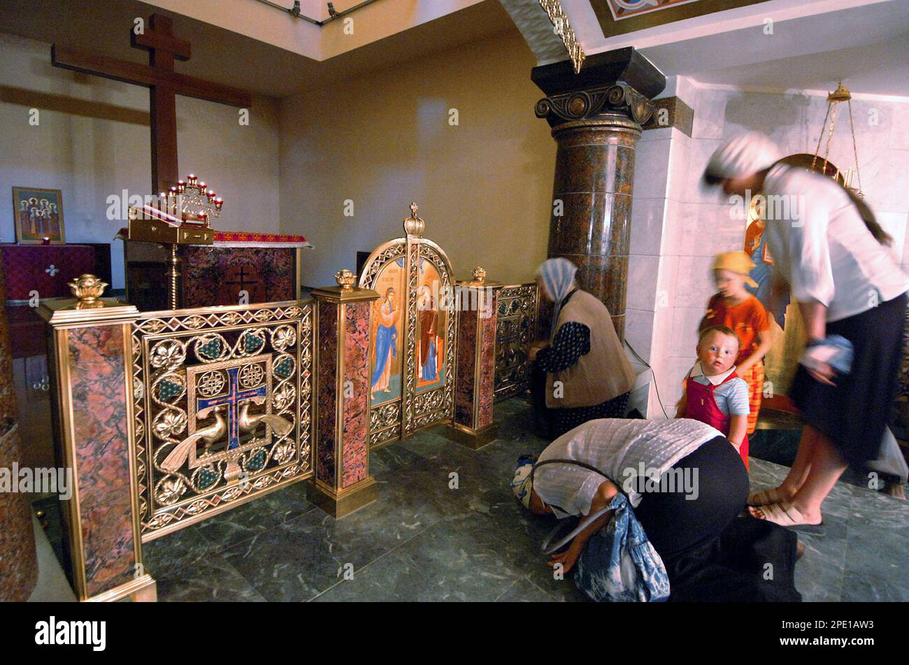 Russian Orthodox faithful cross themselves at the memorial marking the ...